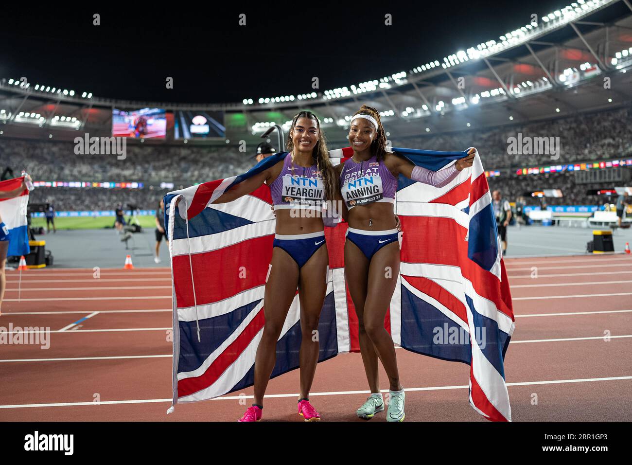 Amber Anning and Nicole Yeargin with her country's flag in the 4x400 ...