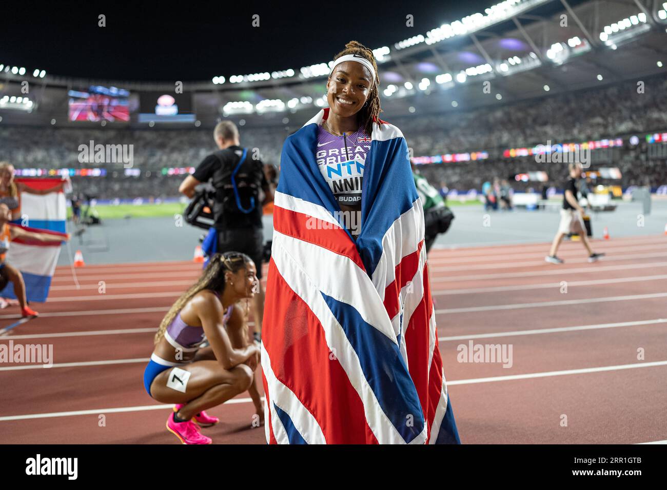 Amber Anning celebrating her medal with her country's flag in the 4x400 ...
