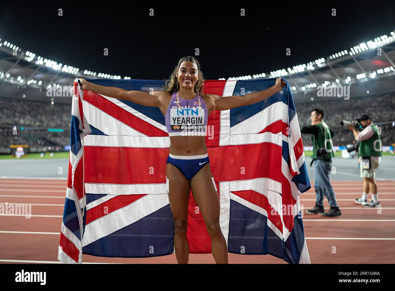Nicole Yeargin celebrating her medal with her country's flag in the ...