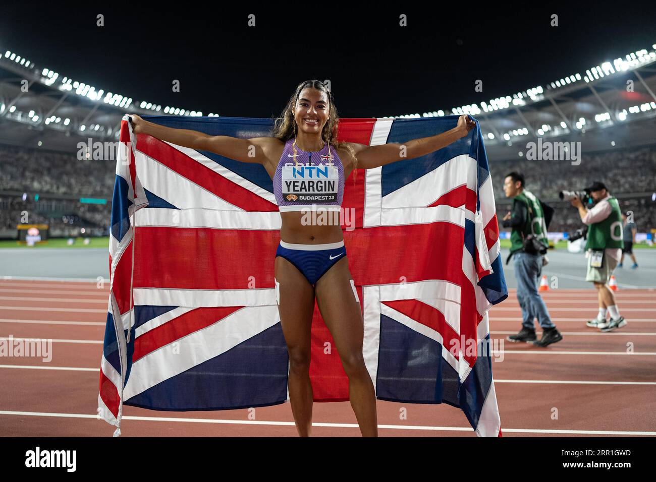 Nicole Yeargin celebrating her medal with her country's flag in the ...