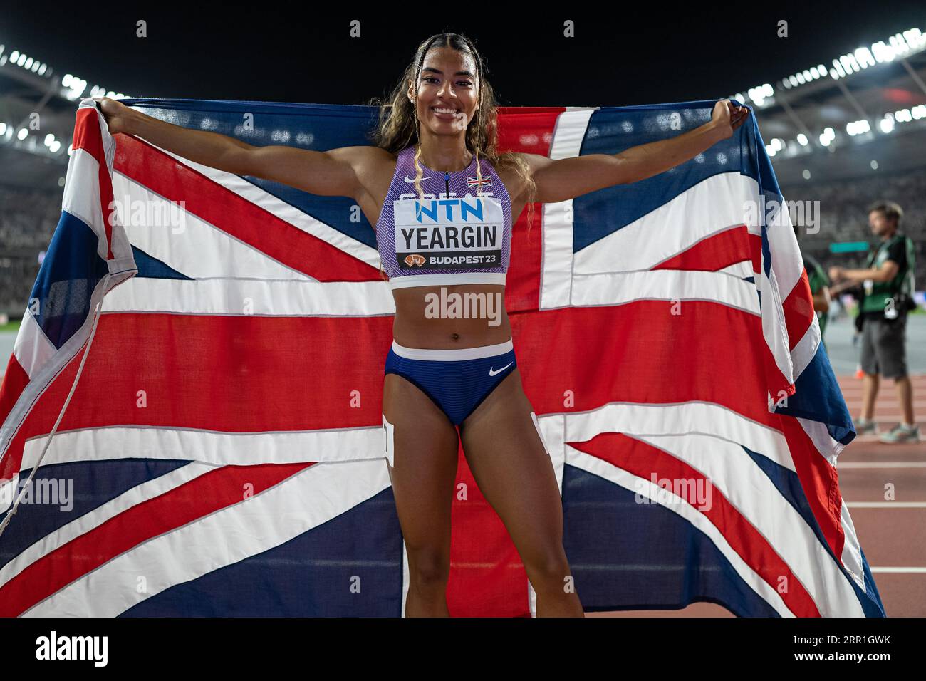 Nicole Yeargin celebrating her medal with her country's flag in the ...