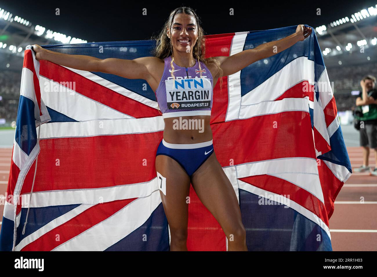 Nicole Yeargin celebrating her medal with her country's flag in the ...