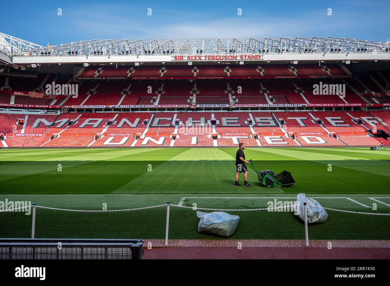 Groundsman mowing the pitch at Manchester United’s Old Trafford stadium ...