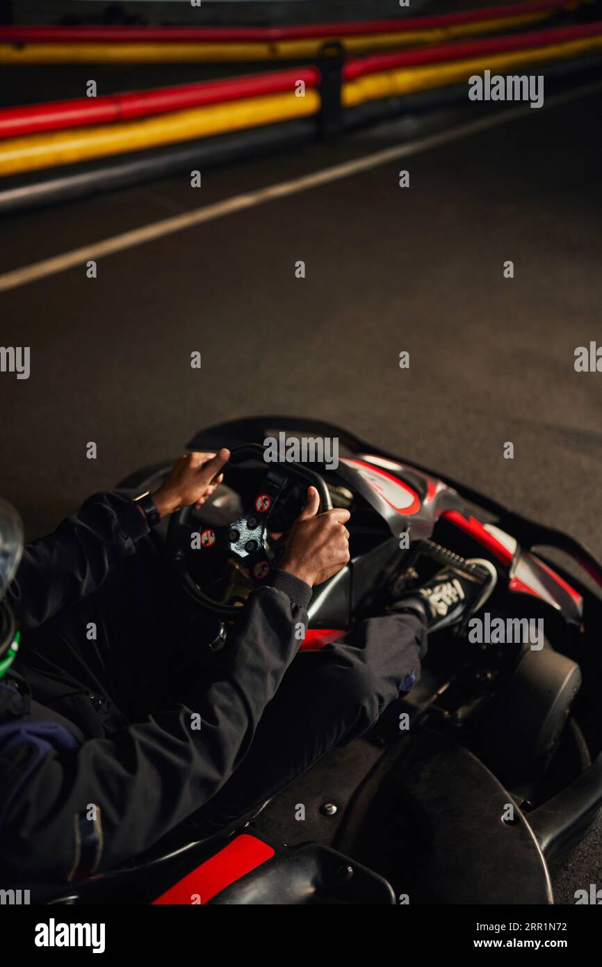 top view of african american go cart racer driving on indoor circuit ...