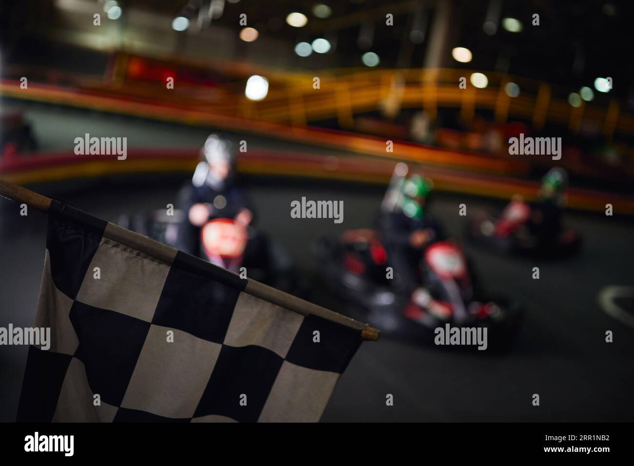 checkered black and white racing flag with drivers on blurred backdrop ...