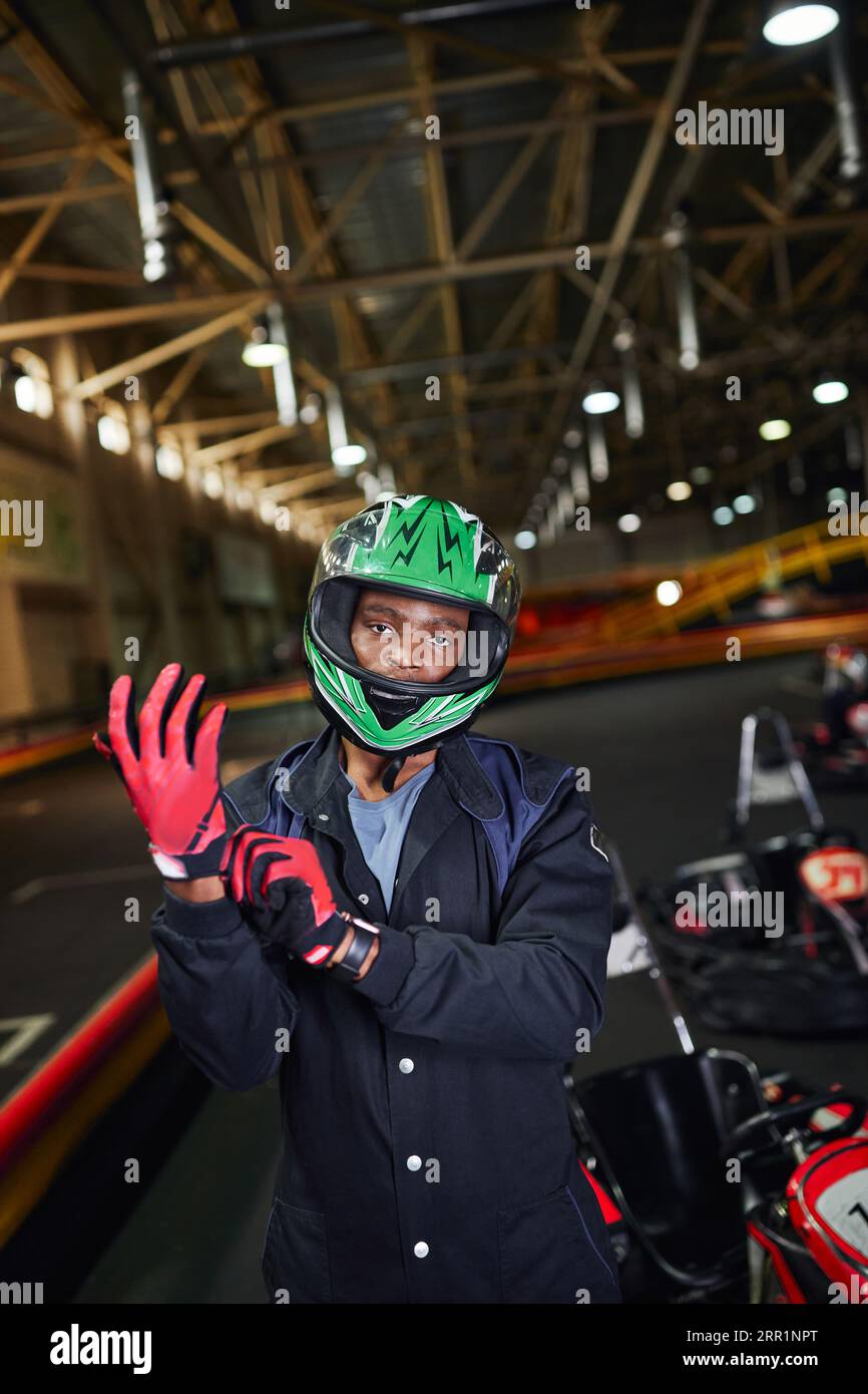 ambitious african american motorsports driver in helmet wearing gloves ...
