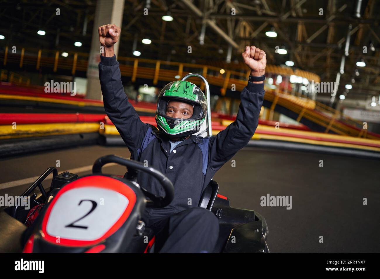 Go kart speed drive, excited african american driver in helmet raising ...