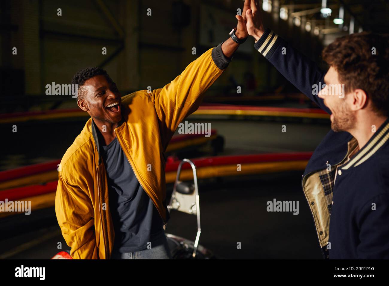 excited african american man giving high five to friend inside of ...