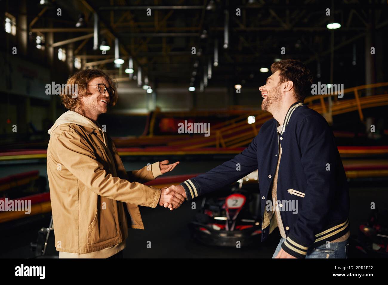 happy man in glasses shaking hands with excited friend inside of ...