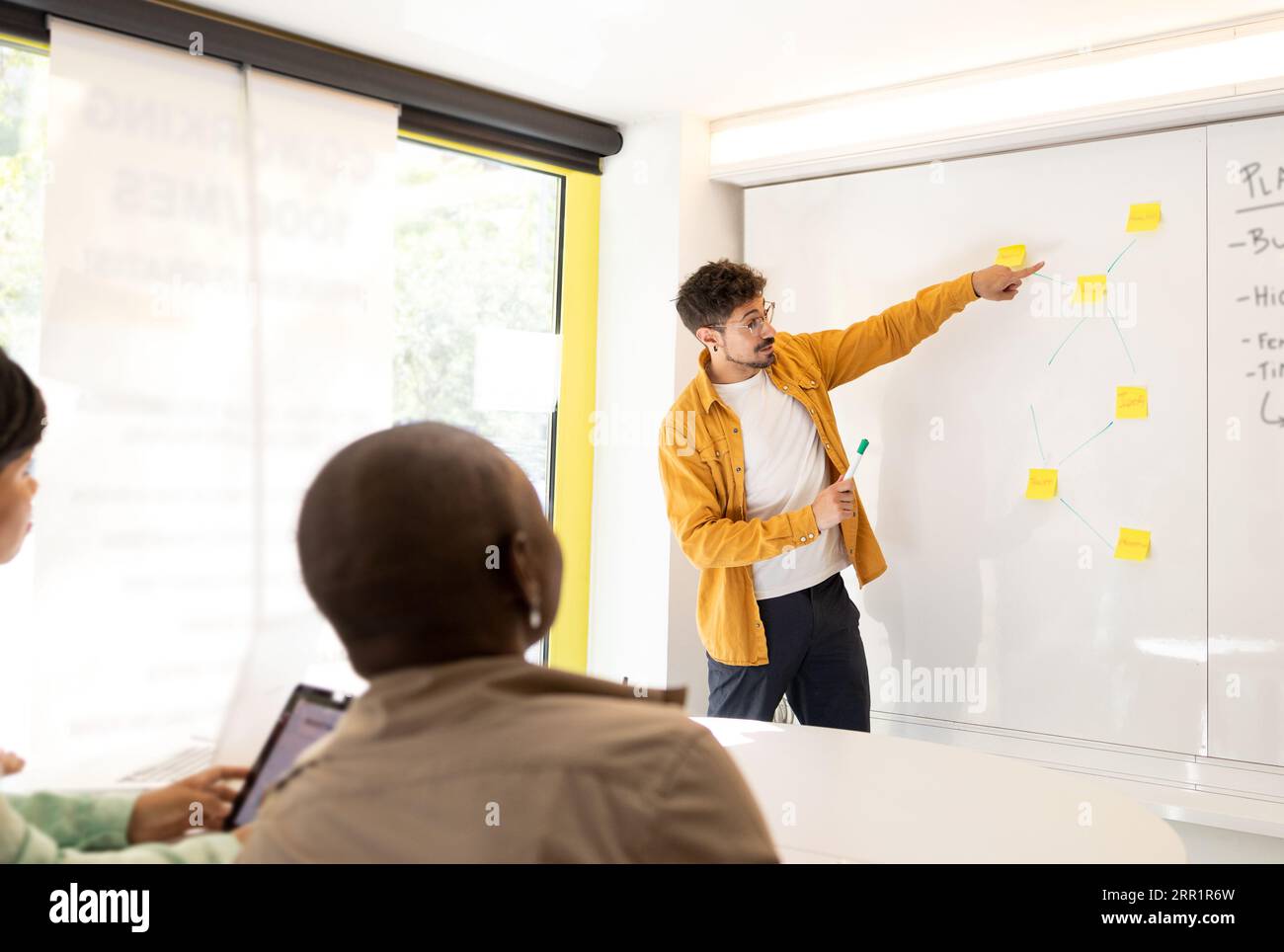 Back view of multiethnic colleagues gathering together in modern office ...