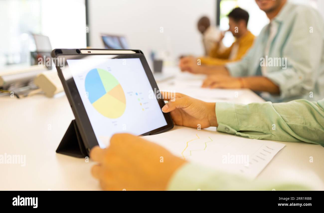 Anonymous male looking at screen of tablet while sitting with ...