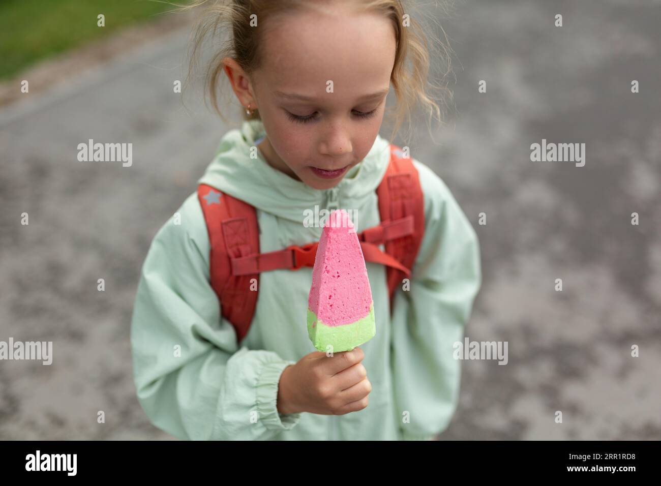 Cute girl child with backpack while standing on path of park and ...