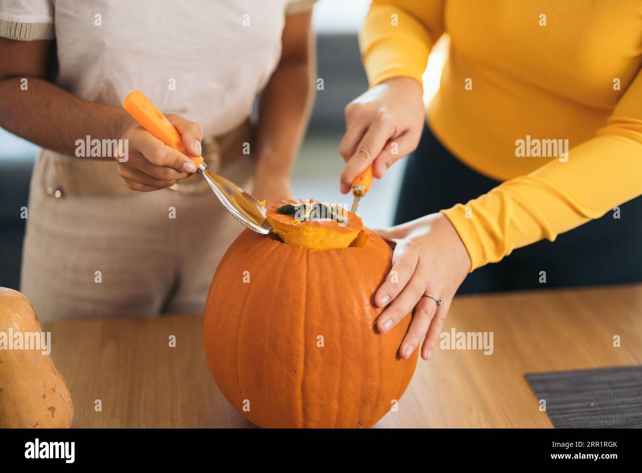 High angle of crop anonymous female friends standing at table and ...