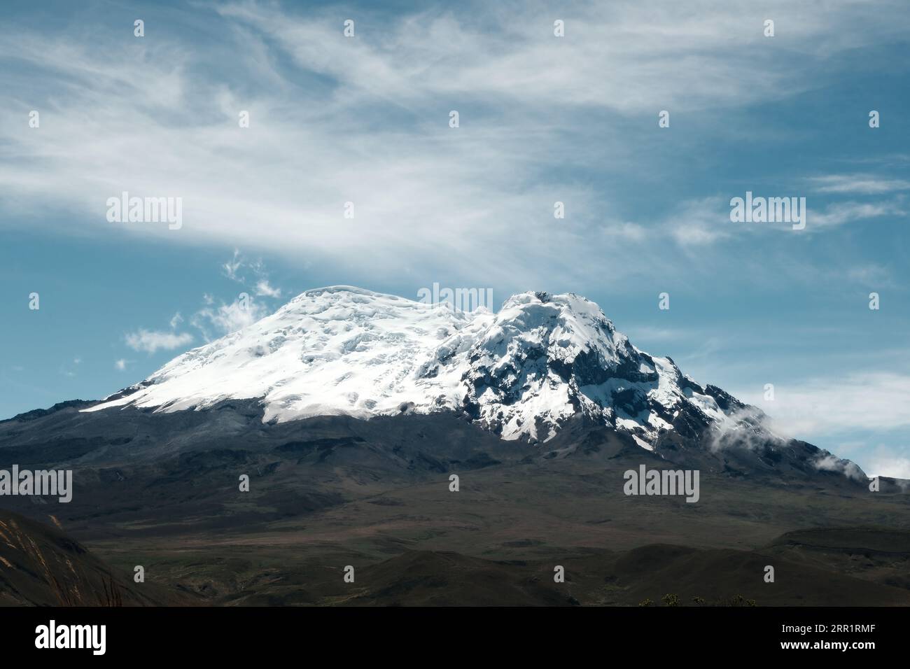 Picturesque landscape of Antisana volcano against blue sky with fluffy ...