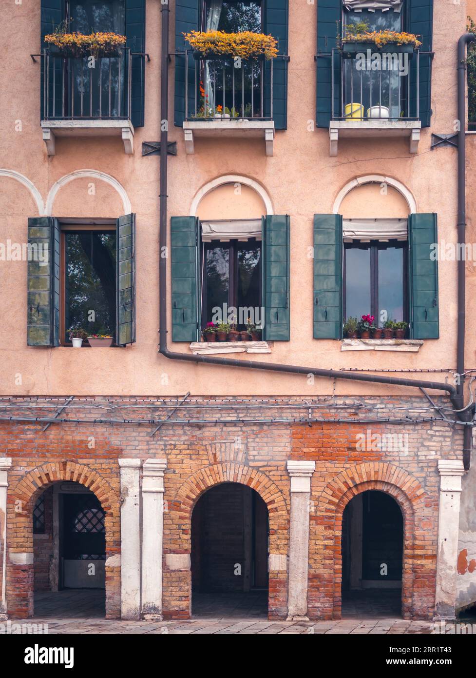 Picturesque exterior of old colorful building with flowers on windows ...