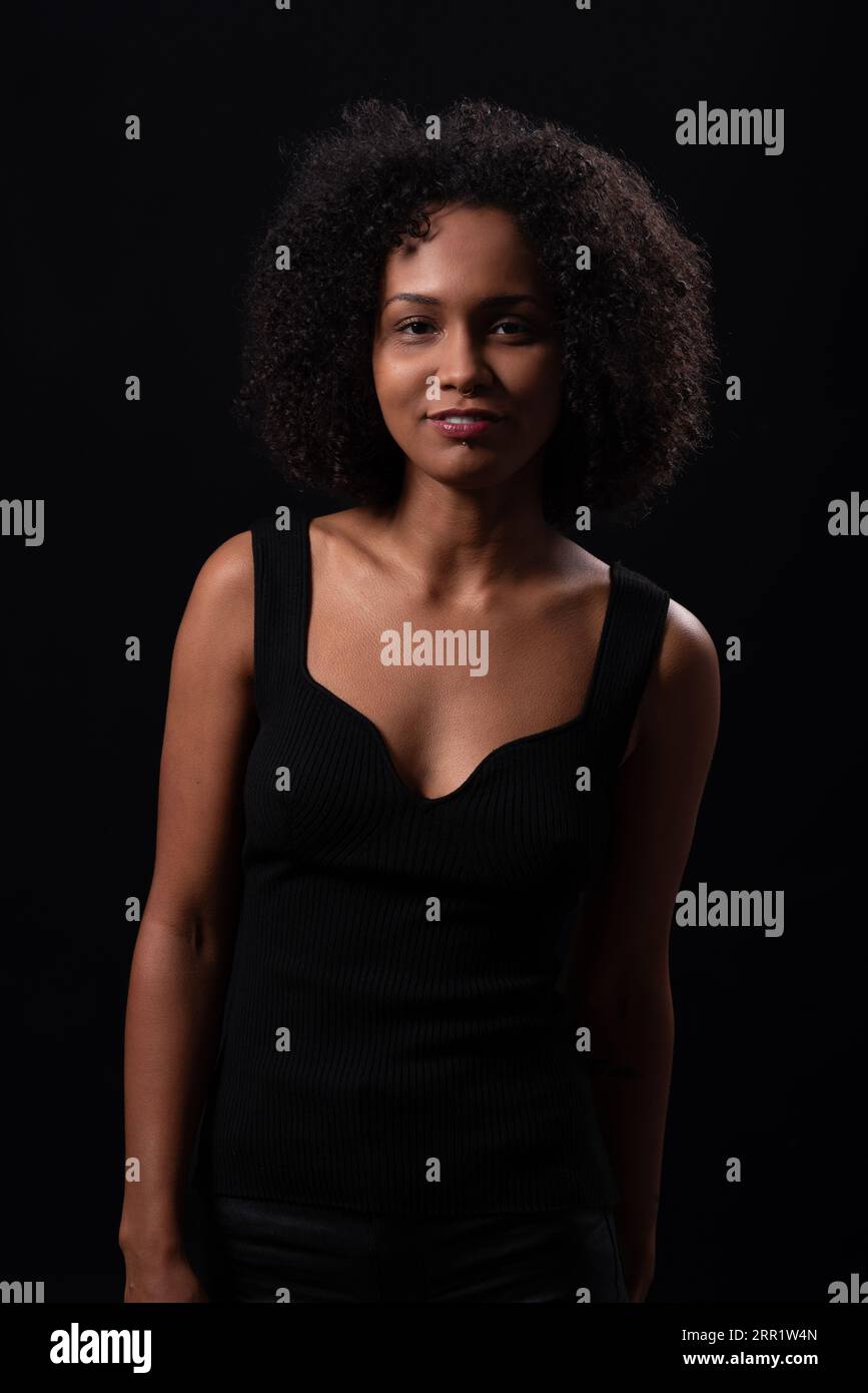 Smiling young Hispanic female model with Afro hairstyle in black ...