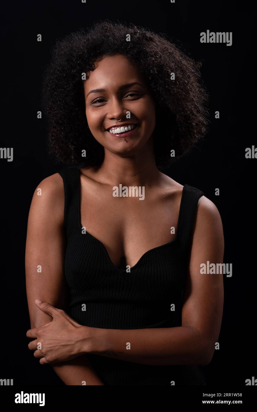 Smiling young Hispanic female model with Afro hairstyle in black ...