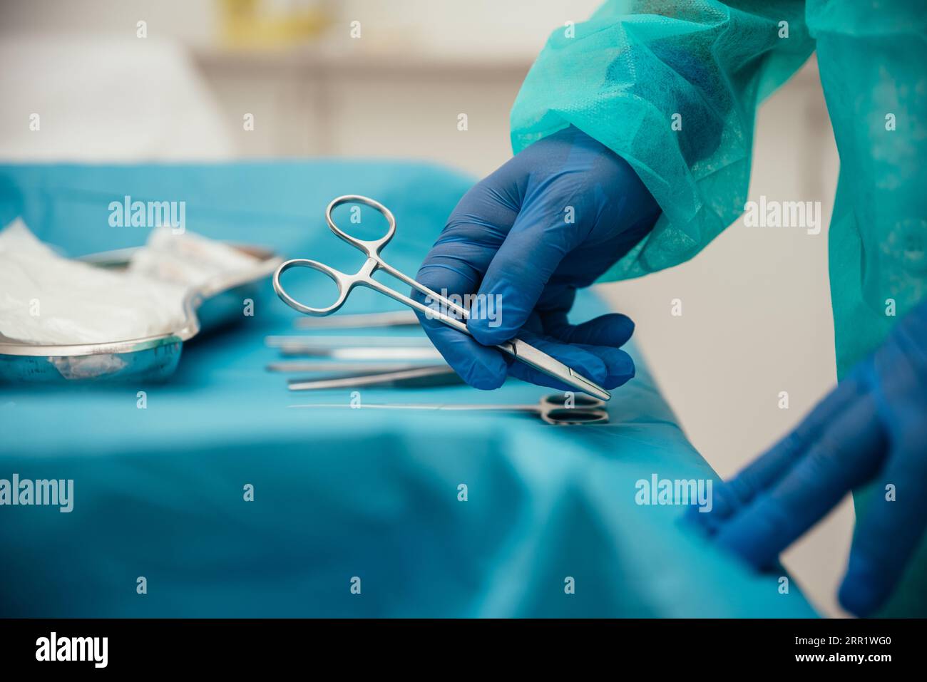 Crop anonymous male doctor in sterile robe and gloves putting surgical ...