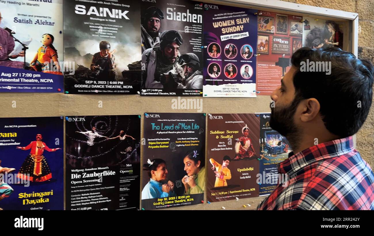 A local man views program posters at the entrance of the National ...