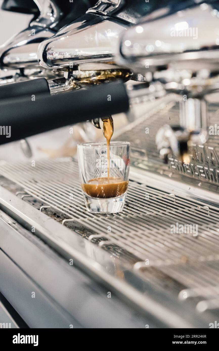 close-up Espresso dripping from portafilter of coffee machine into ...