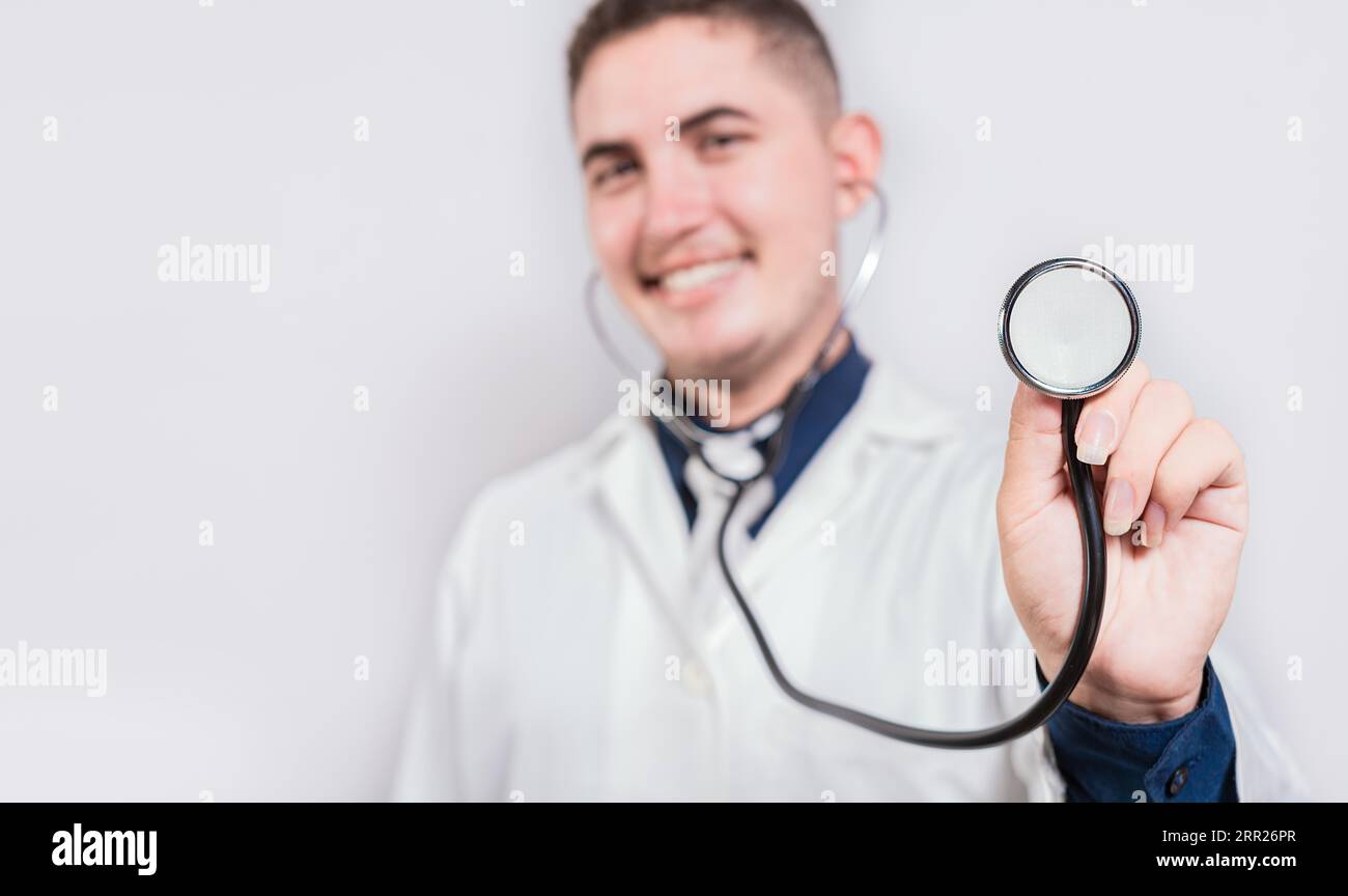 Happy young doctor holding stethoscope looking at camera. Portrait of ...