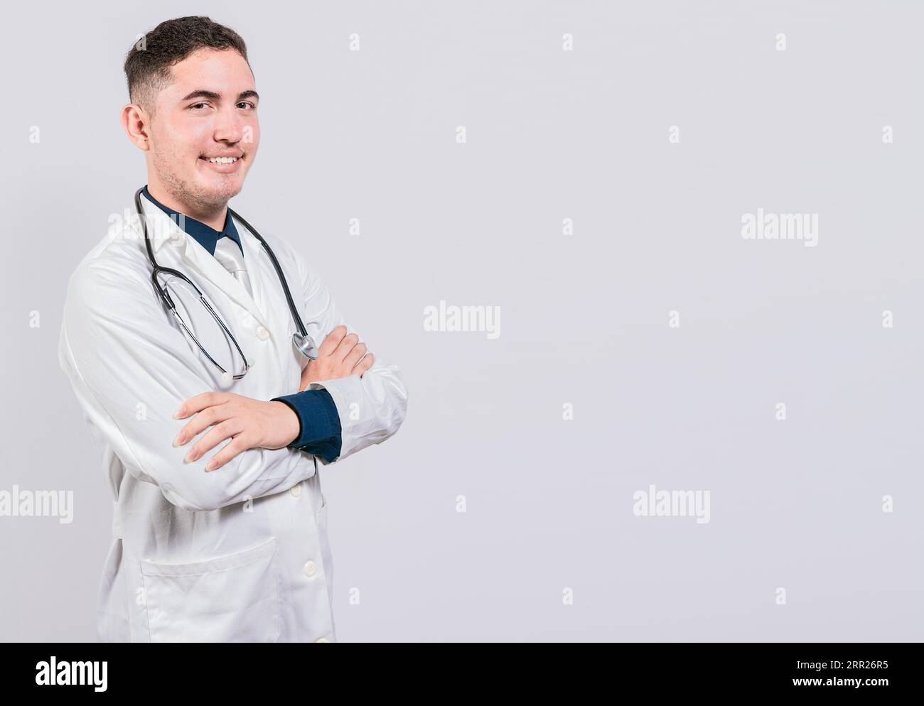 Smiling latin doctor with crossed arms on isolated background. Cheerful ...