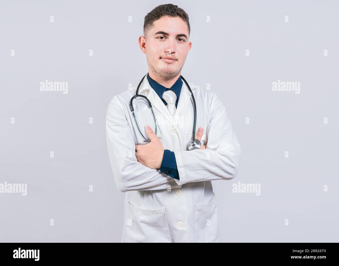 Portrait of handsome doctor with arms crossed isolated. Latin doctor ...
