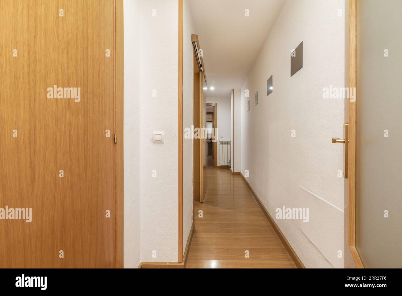 A hallway with built-in wardrobes and access doors to other rooms with ...