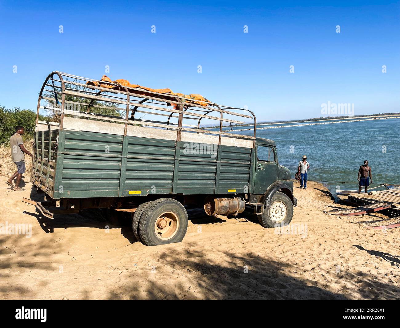 Madagascar, Tsiribihina river, young men tow barge on river Stock Photo ...
