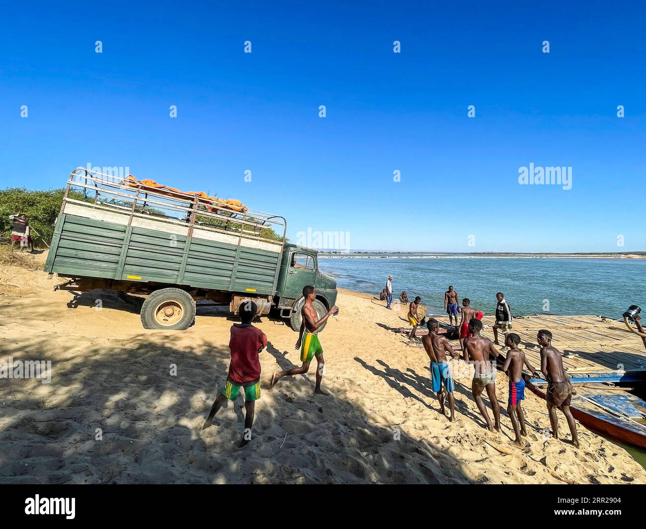 Madagascar, Tsiribihina river, young men tow barge on river Stock Photo ...