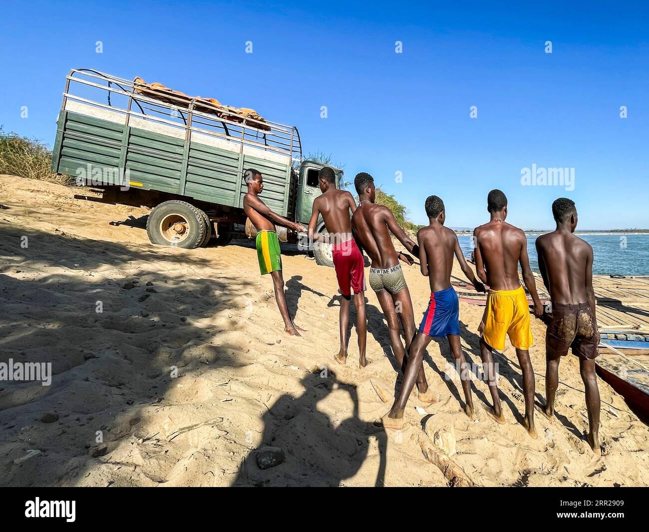 Madagascar, Tsiribihina river, young men tow barge on river Stock Photo ...