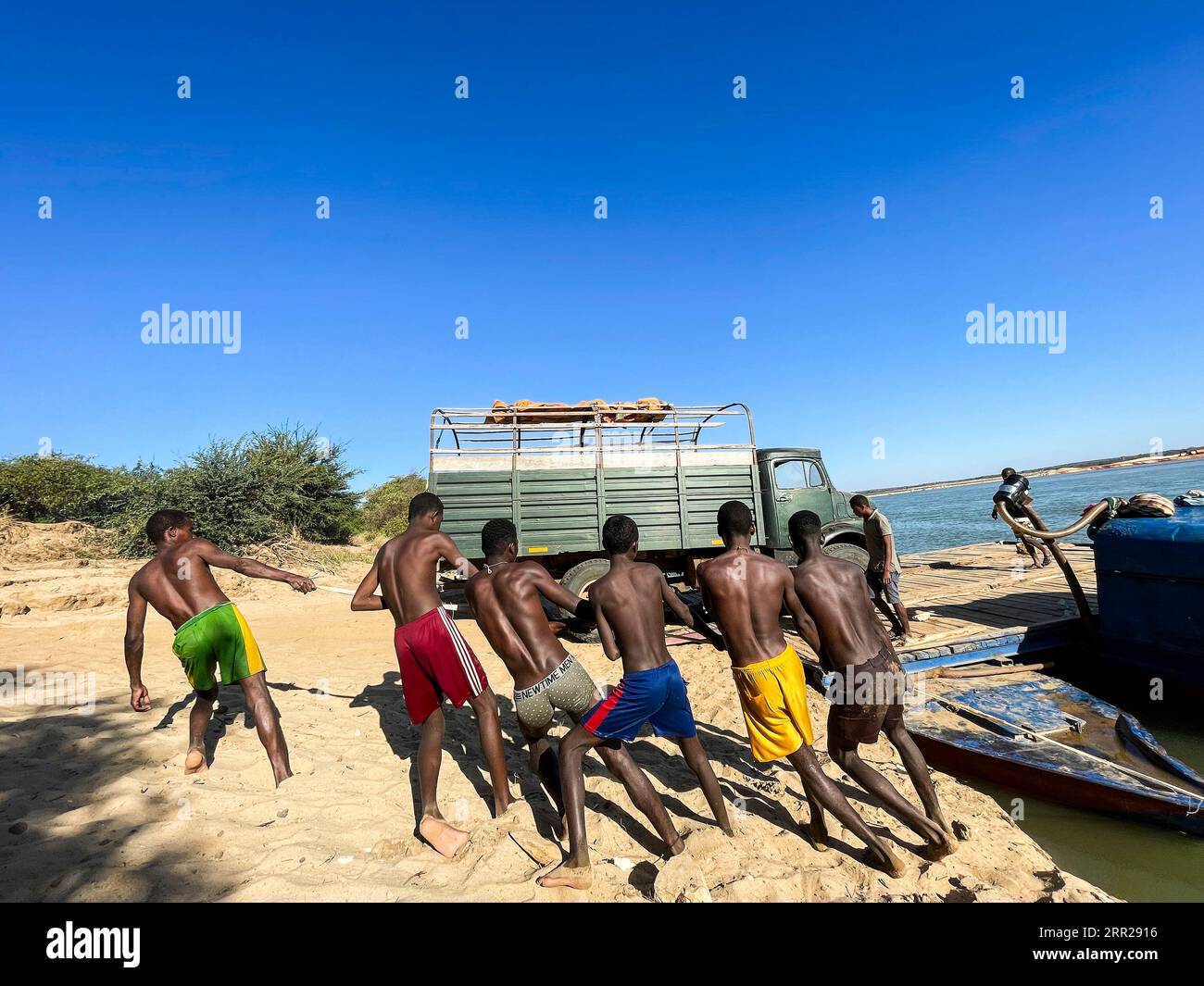 Madagascar, Tsiribihina river, young men tow barge on river Stock Photo ...