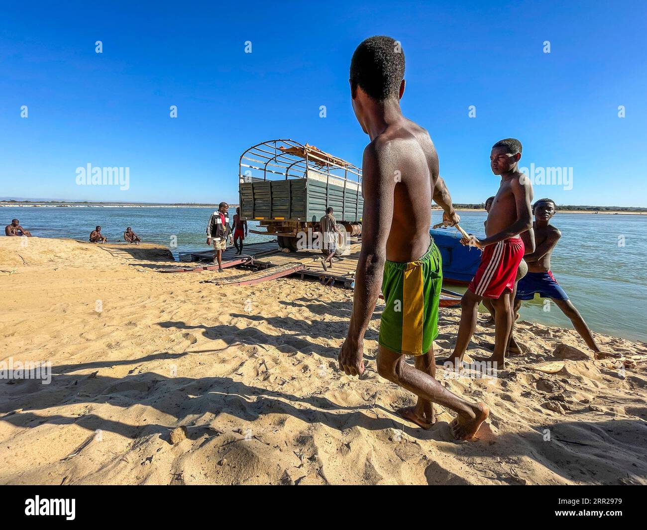 Madagascar, Tsiribihina river, young men tow barge on river Stock Photo ...