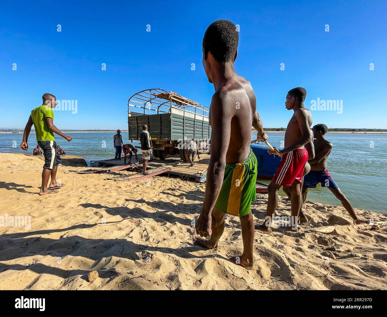 Madagascar, Tsiribihina river, young men tow barge on river Stock Photo ...