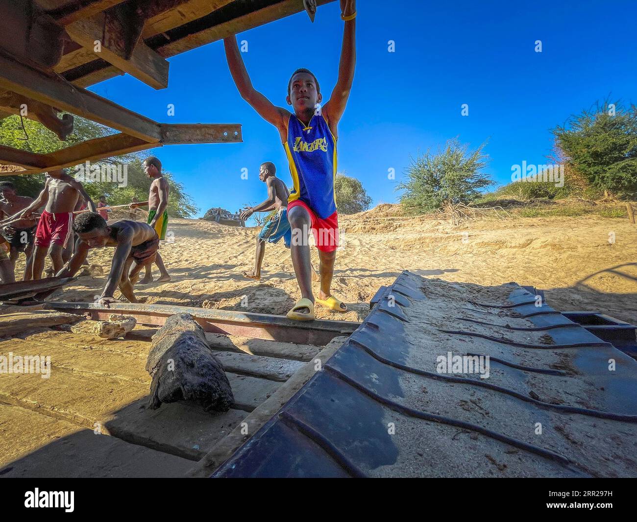 Madagascar, Tsiribihina river, young men tow barge on river Stock Photo ...
