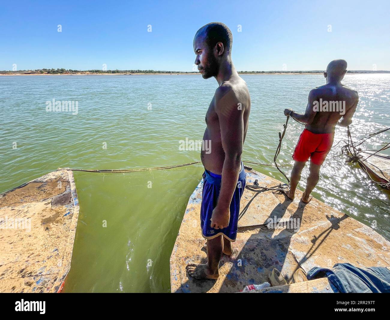 Madagascar, Tsiribihina river, young men tow barge on river Stock Photo ...