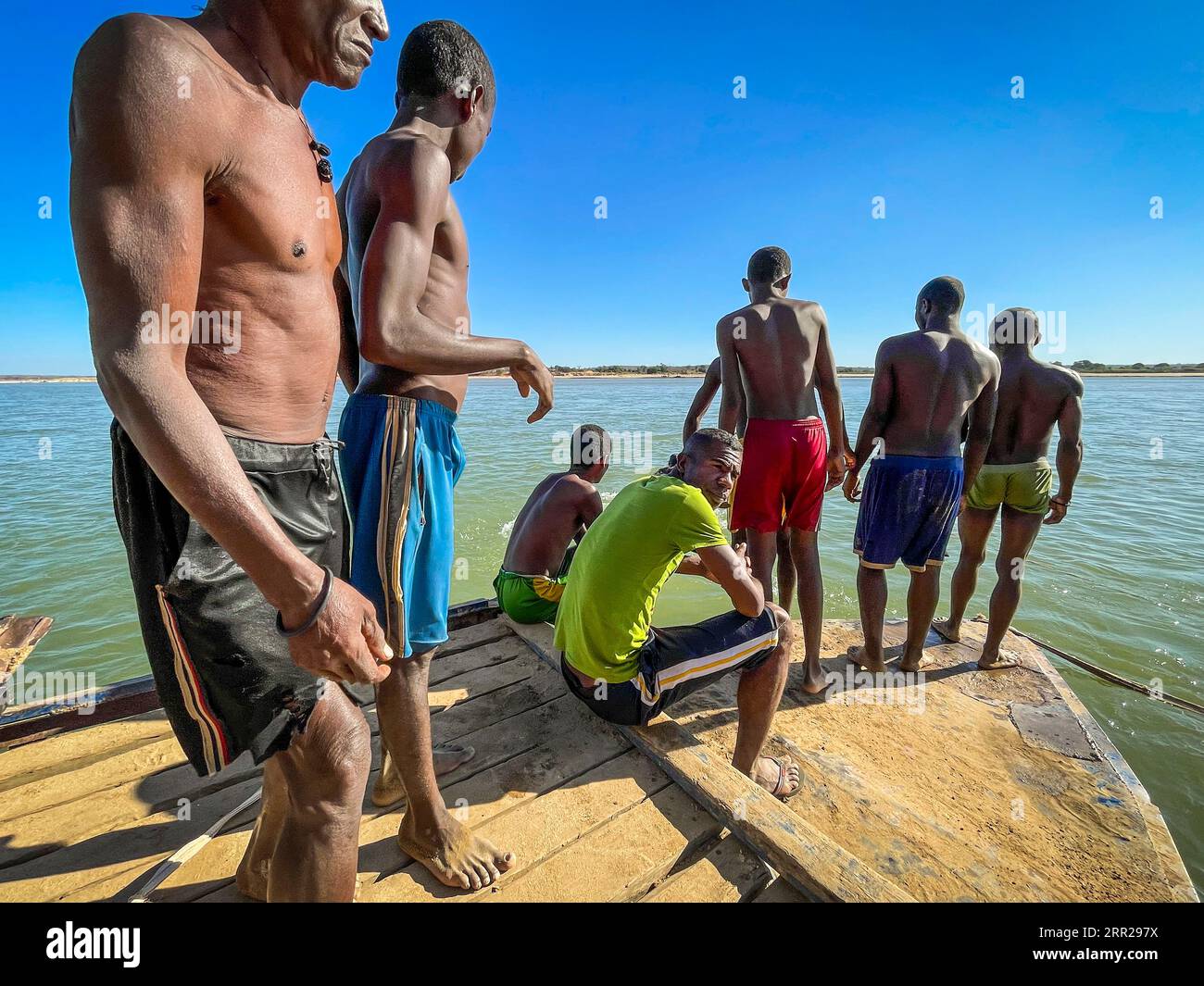 Madagascar, Tsiribihina river, young men tow barge on river Stock Photo ...