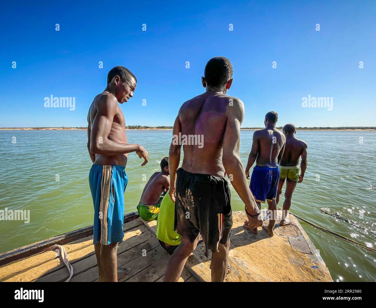Madagascar, Tsiribihina river, young men tow barge on river Stock Photo ...