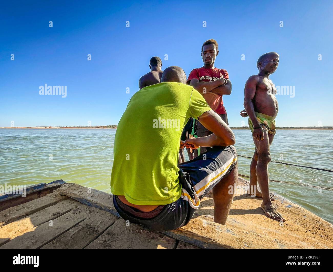 Madagascar, Tsiribihina river, young men tow barge on river Stock Photo ...