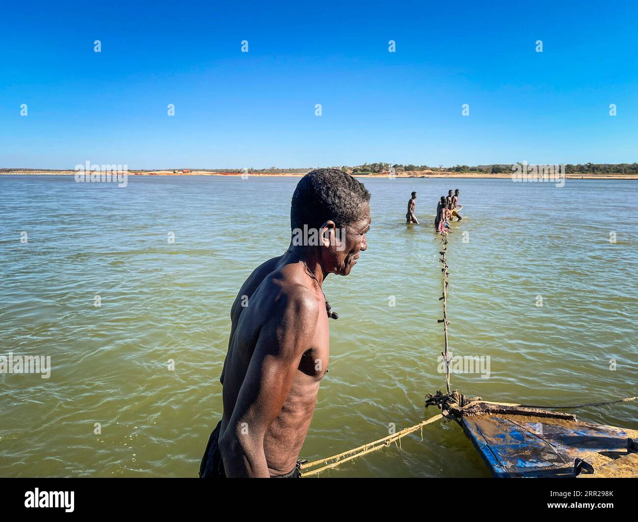 Madagascar, Tsiribihina river, young men tow barge on river Stock Photo ...