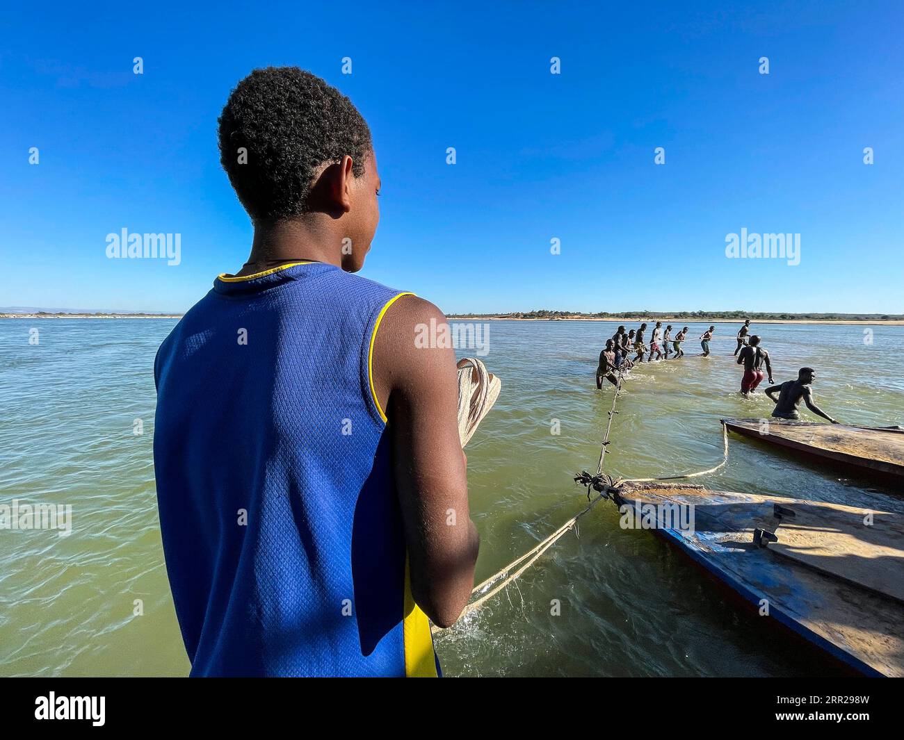 Madagascar, Tsiribihina river, young men tow barge on river Stock Photo ...