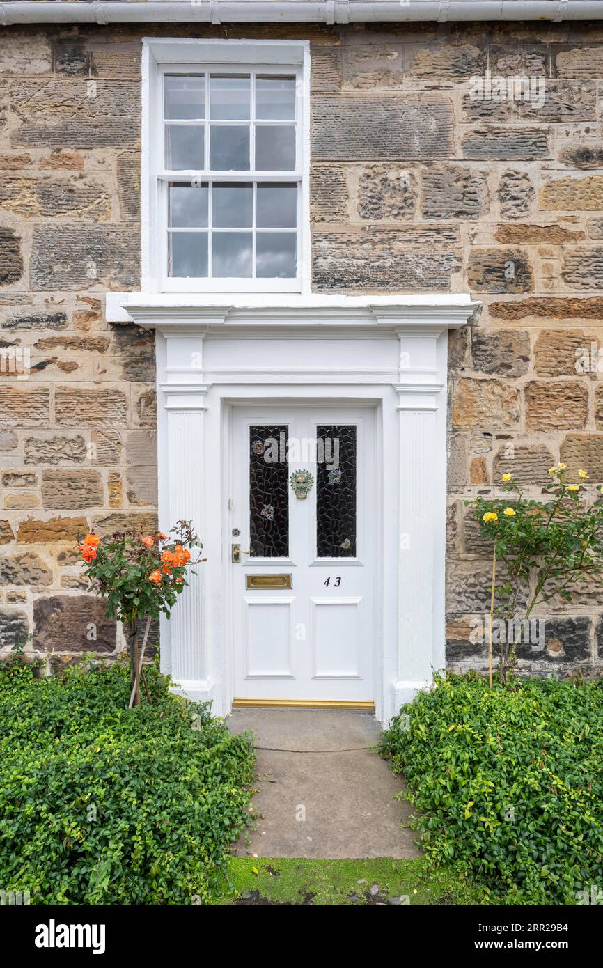 White front door on an old stone house, in the old town of St Andrews ...