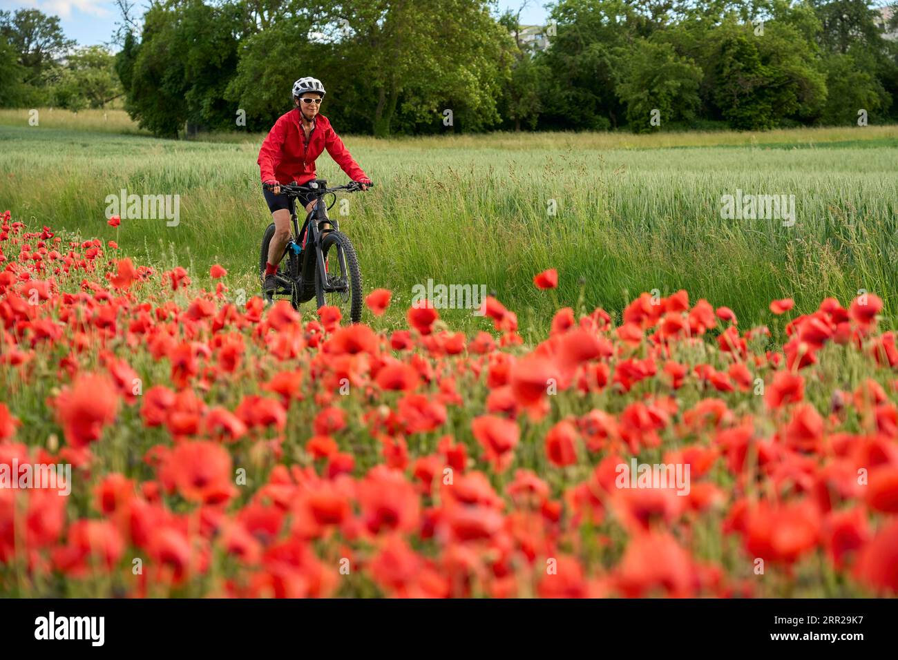 Nice, active senior citizen, riding her electric bike in a huge field ...