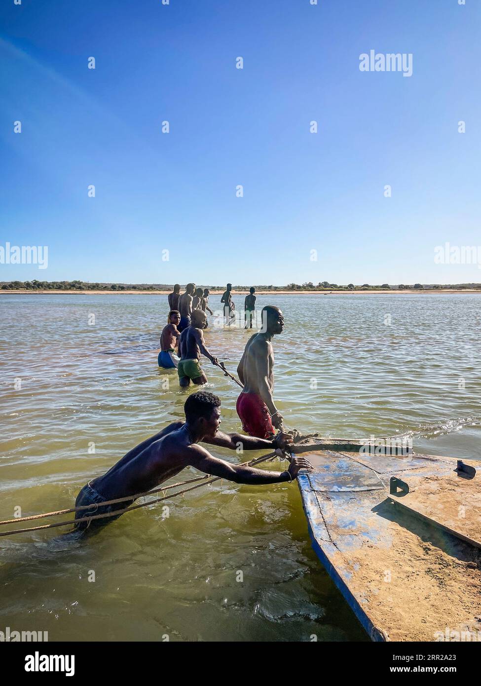 Madagascar, Tsiribihina river, young men tow barge on river Stock Photo ...