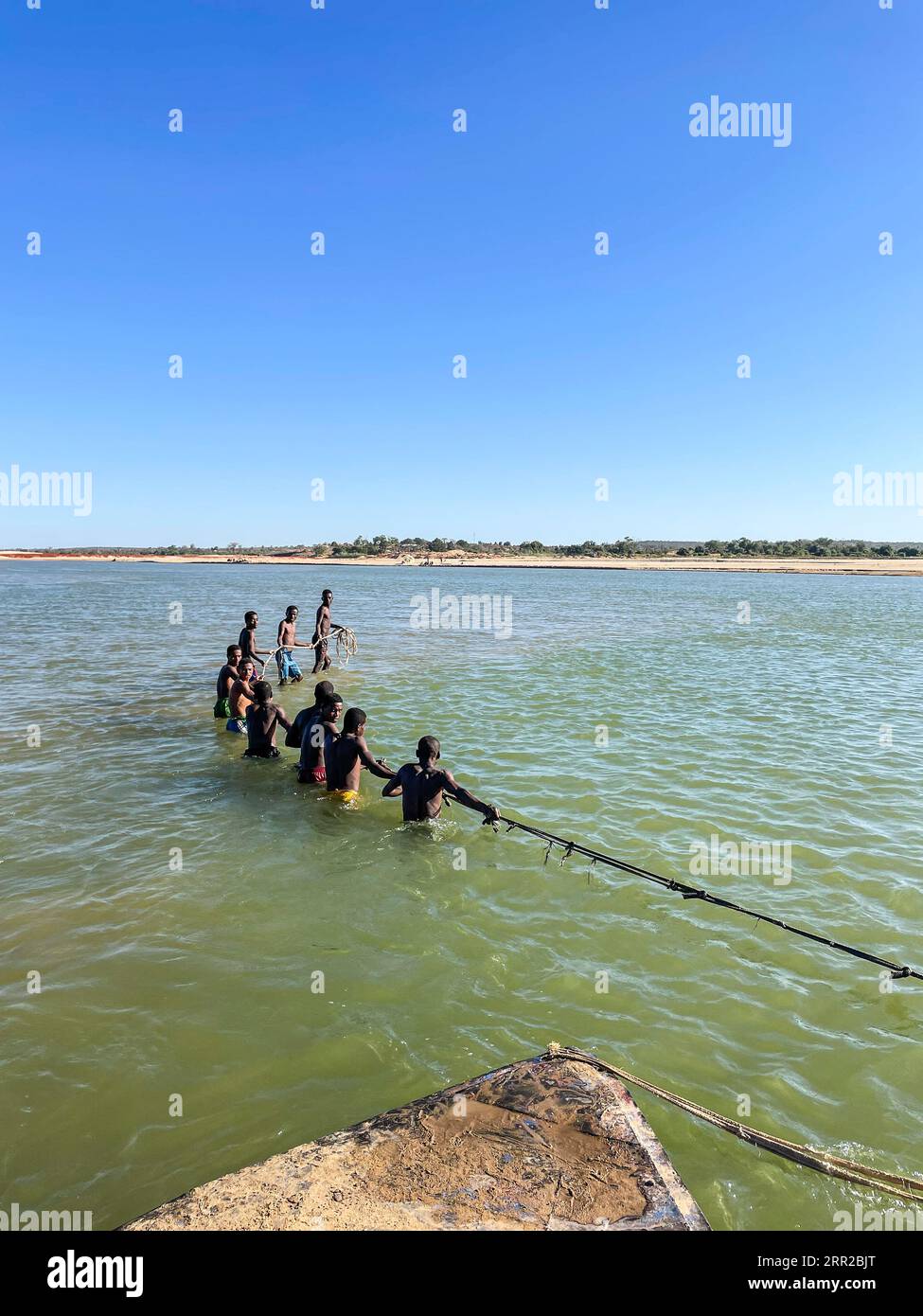 Madagascar, Tsiribihina river, young men tow barge on river Stock Photo ...
