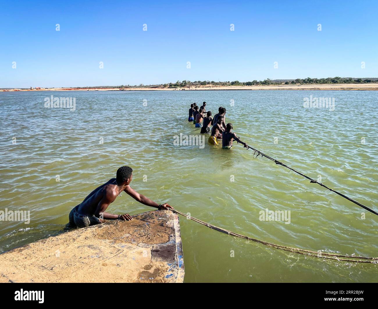 Madagascar, Tsiribihina river, young men tow barge on river Stock Photo ...