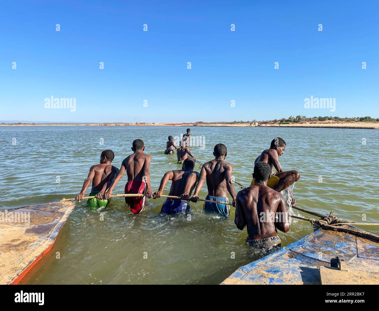 Madagascar, Tsiribihina river, young men tow barge on river Stock Photo ...