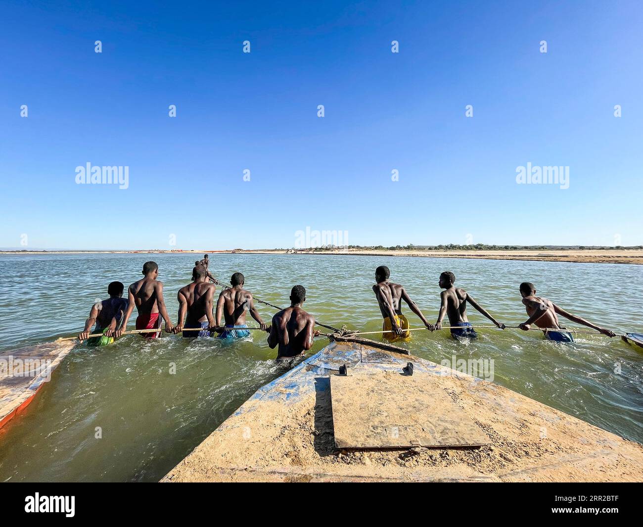 Madagascar, Tsiribihina river, young men tow barge on river Stock Photo ...