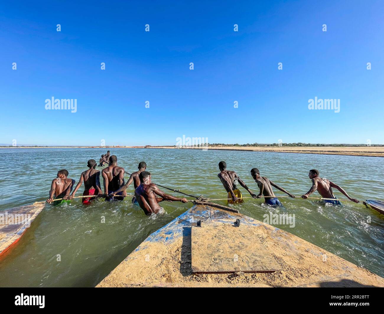Madagascar, Tsiribihina river, young men tow barge on river Stock Photo ...
