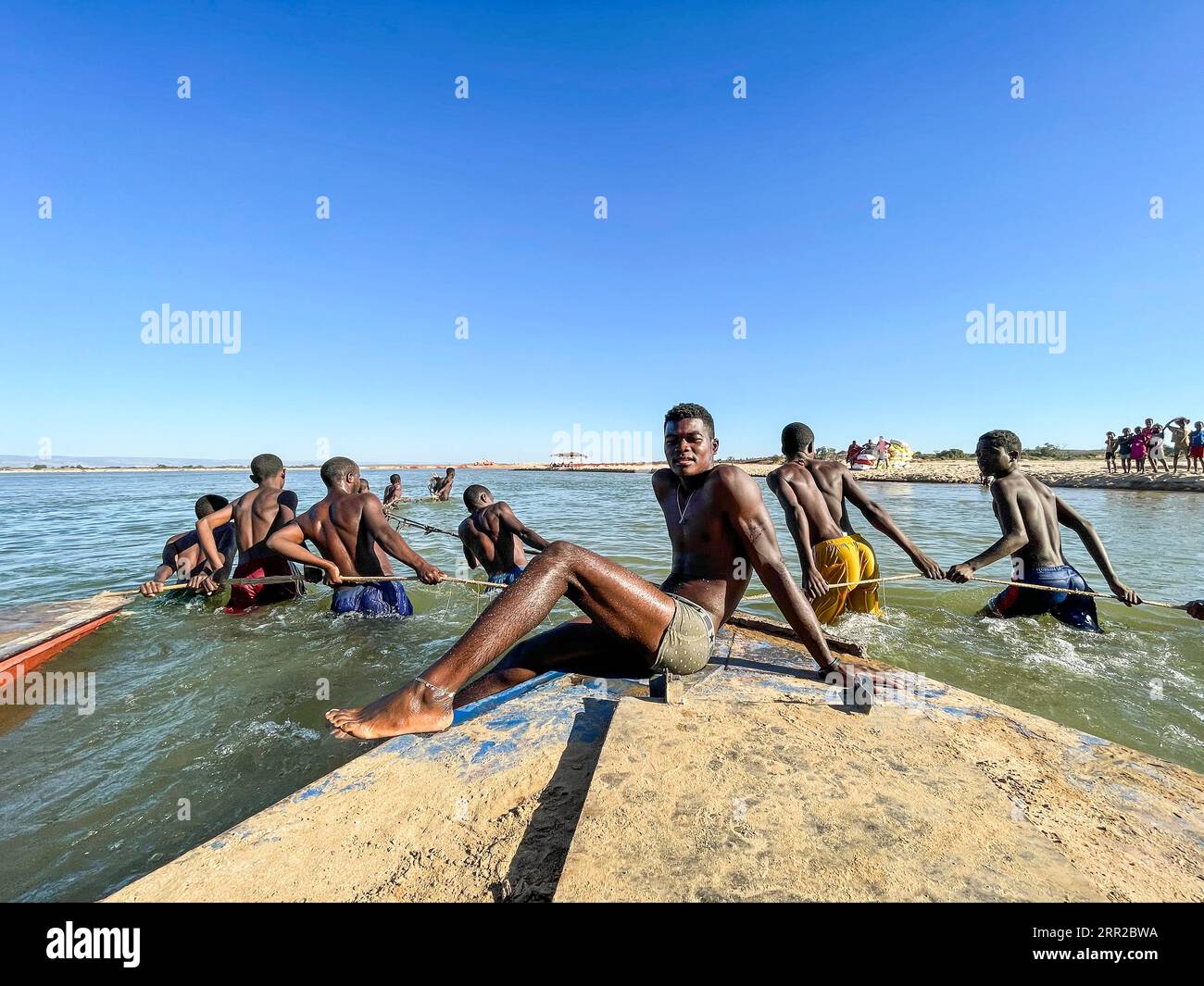 Madagascar, Tsiribihina river, young men tow barge on river Stock Photo ...